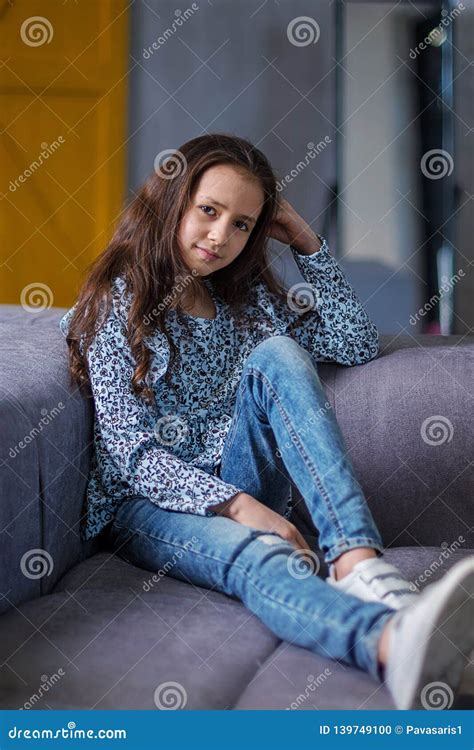 Teenage Girl With Long Hair Sitting On A Comfortable Sofa Resting