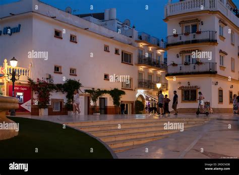 People Walk Through The Cozy Neighborhood Of La Carihuela In The City Of Torremolinos In The