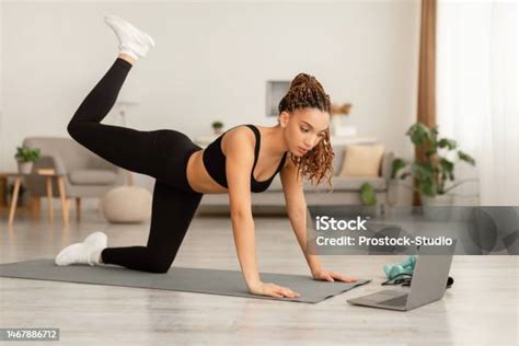 스포티 한 아프리카 여성은 실내에서 네 발로 노트북 근처에서 운동합니다 기어가기에 대한 스톡 사진 및 기타 이미지 기어가기 이완 운동 땋은 머리 Istock