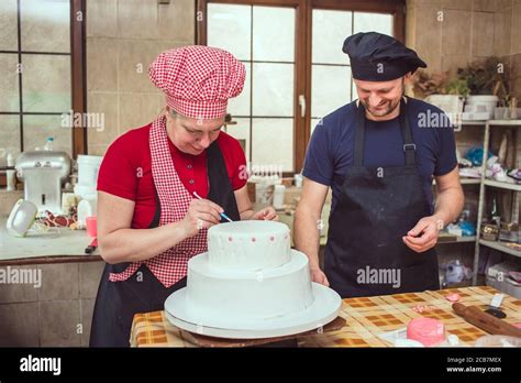 Female Chef In Red Work Wear In Pasty Shop Finishing Decoration On