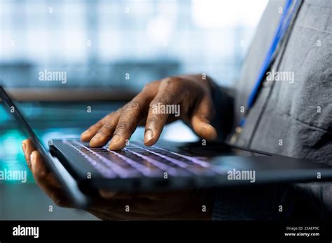 Employee In Data Center Typing On Laptop Keyboard Analyzing Metrics Optimizing Storage Volumes