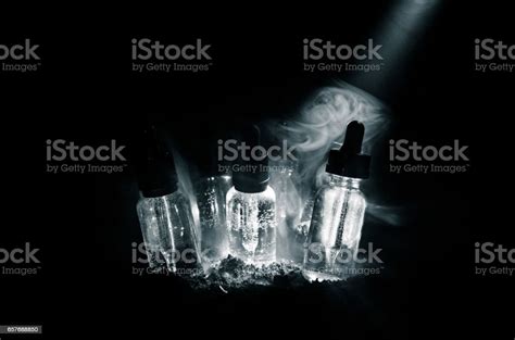 Vape 개념입니다 구름과 어두운 배경에 Vape 액체 병 연기 빛 효과입니다 배경 또는 Vape 광고로 유용 합니다 0명에