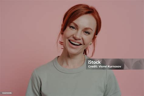 스튜디오에서 분홍색 배경에 고립 된 포즈를 취하는 캐주얼 한 옷을 입은 젊은 매력적인 웃는 빨간 머리 여성 35 39세에 대한 스톡 사진 및 기타 이미지 Istock