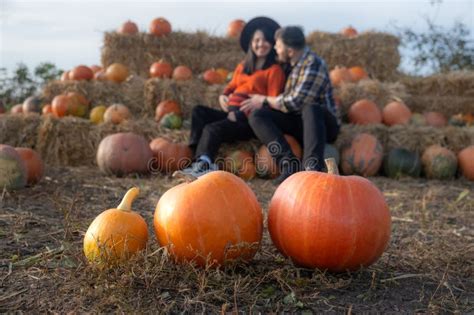 Couple Sitting On Hay Bales In A Pumpkin Patch Stock Image Image Of