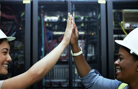 Cropped Shot Of Two Attractive Female Programmers High Fiving In A