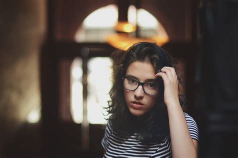 배경 화면 검은 여자들 초상화 안경을 든 여성 갈색 머리의 뷰어를보고 사진술 머리카락을 손에 넣다 유행 줄무늬가있는 의복 감정 리아 티아 소녀