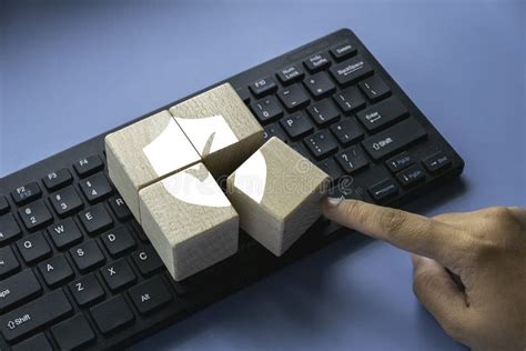 Wooden Cube With Shield Logo And Check Mark Over A Computer Keyboard