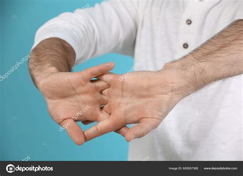 Man Cracking His Knuckles Light Blue Background Closeup Bad Habit
