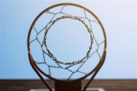 푸른 하늘 배경에 금속 그물과 나무 백보드가 있는 농구 후프 야외 농구 코트 길거리 야외 운동장의 레크리에이션 스포츠 장비 거리의 놀이터 하단보기 0명에 대한 스톡 사진 및