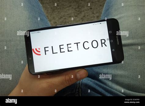 Man Holding Smartphone With Fleetcor Technologies Inc Company Logo