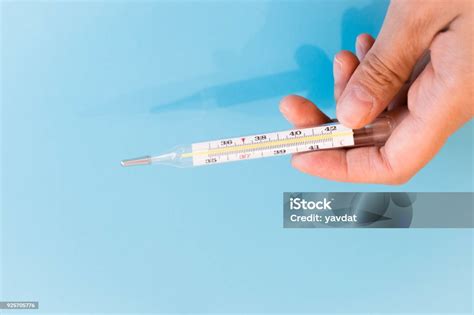 닫기 최대 전통적인 손잡고 체온을 측정 하기 위한 온도계 온도계를 바라보는 여자의 근접 촬영 샷입니다 여자는 온도 측정합니다