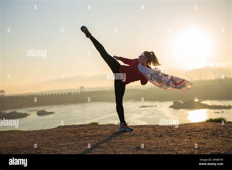 Woman With Flag Doing Martial Arts Exercises At Sunset Light Stock