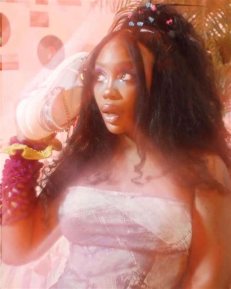 A Woman In A White Dress Holding A Cell Phone