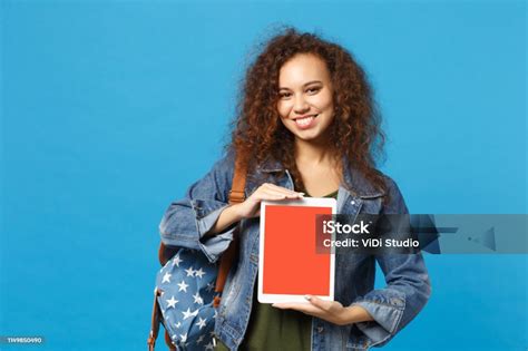 데님 옷 배낭 홀드 패드 Pc 파란색 배경 스튜디오 초상화에 고립에서 젊은 아프리카계 미국인 소녀 십 대 학생 고등학교 대학 대학 개념에서 교육 복사 공간을 모의 합니다