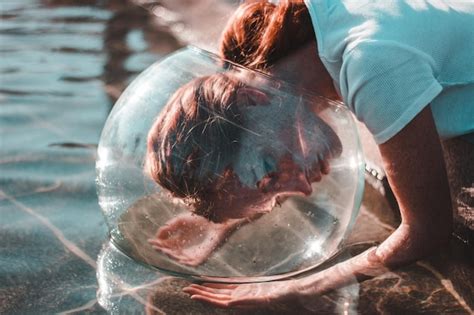 Premium Photo Close Up Of Woman Wearing Glass Container At Lake