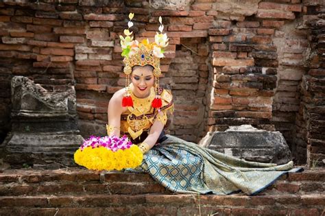 Premium Photo Portrait Of A Smiling Girl Sitting On Stone Wall