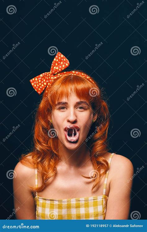 La Fille Redhaired Séduisante a Gonflé Une Boule De Gomme à Mâcher Qu