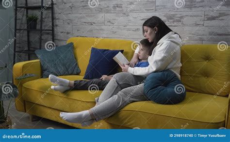 Full Shot Mom And Son Sitting On The Couch Reading A Book Stock Footage