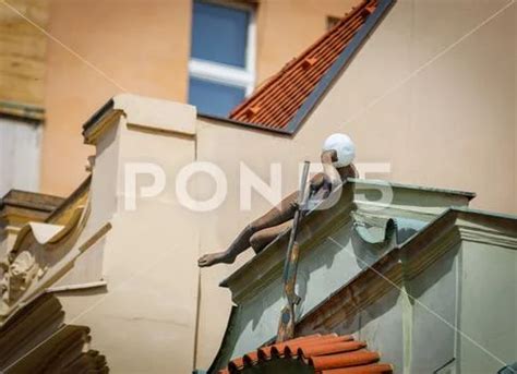 A Sculpture Of A Naked Girl Lying On The Edge Of The Roof Of A Building