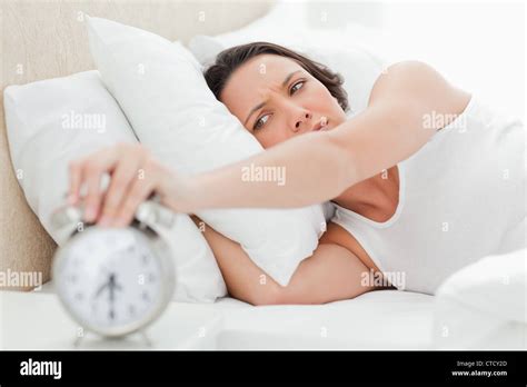 Woman Turning Off Her Alarm Clock Stock Photo Alamy