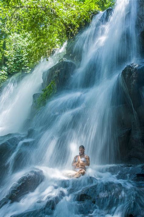 Attractive Woman Sitting At Rock In Yoga Pose For Spiritual Relaxation
