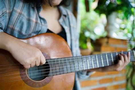 Las manos de una joven feliz tocando la guitarra acústica solo componen
