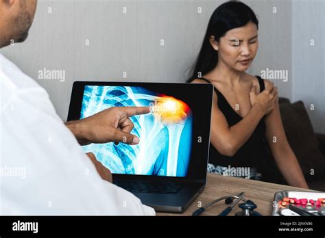 Doctor Showing A X Ray Of Pain In The Shoulder On A Laptop Woman