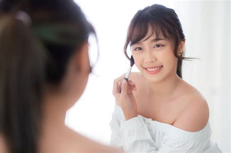 아름다움 초상화 젊은 아시아 여자 웃는 얼굴 블러셔 피부 관리 및 화장품 개념을 들고 여자의 아름 다운 뺨의 브러시로 메이크업을