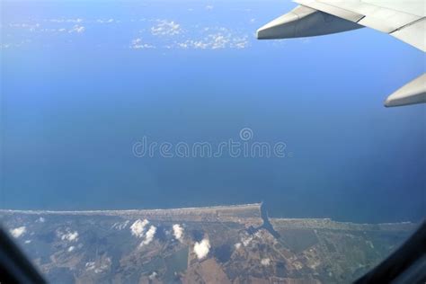 View Through Airplane Window Of Commercial Jet Plane Wing Flying High