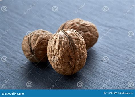 A Stack Of Walnuts Piled Together And Isolated On Dark Background