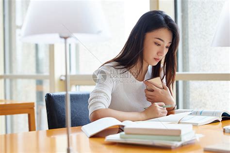 女学生图书馆学习使用手机查资料高清图片下载 正版图片501808417 摄图网