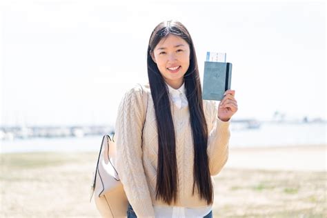 Premium Photo Young Chinese Woman Holding A Passport At Outdoors