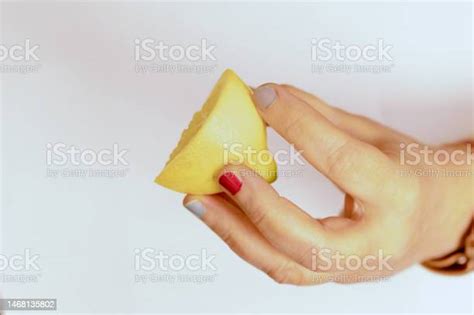손톱이 빨간색으로 칠해진 손은 흰색 배경 앞에 반으로 자른 레몬을 들고 있습니다 개념에 대한 스톡 사진 및 기타 이미지 개념