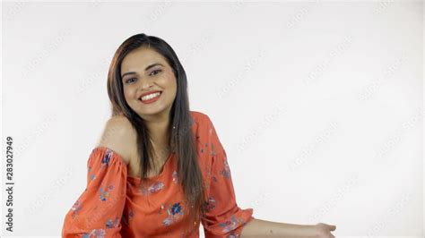 Beautiful Indian Girl Laughing And Bursting A Balloon Isolated Over