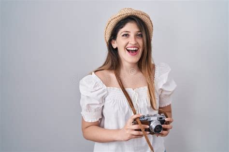 Young Brunette Woman Holding Vintage Camera Smiling And Laughing Hard