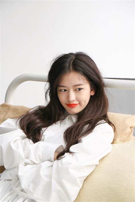 A Woman Sitting On Top Of A Bed With Her Arms Folded Over Her Chest And