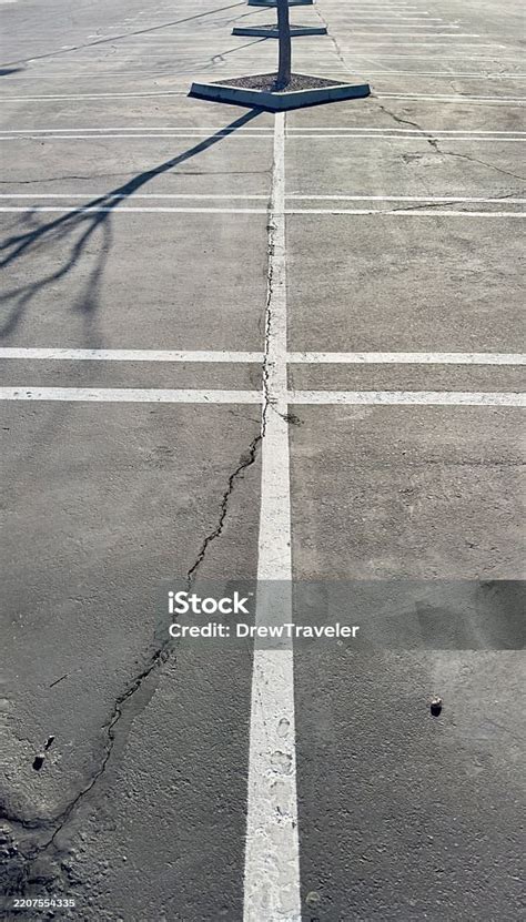 신선한 아스팔트 표면이 있는 빈 주차장 흰색으로 칠해진 선 맑은 하늘 아래 공간을 표시하는 조용하고 고요한 장면 선명한 그림자와 넓은 열린 공간 도시 인프라 비주얼에 이상적