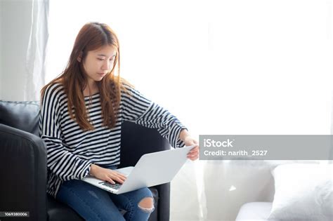 레저의 자 거실 여자 노트북 프리랜서 통신 비즈니스 개념으로 온라인 작업에 대 한 랩톱 컴퓨터를 사용 하 여 세로 젊은 아시아