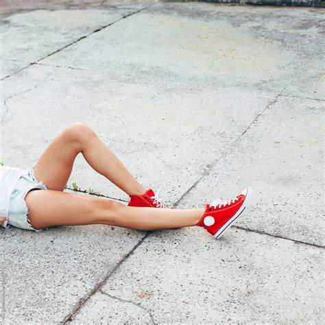 Pretty Sexy Young Woman Lying On The Ground In Short Jeans Shorts By