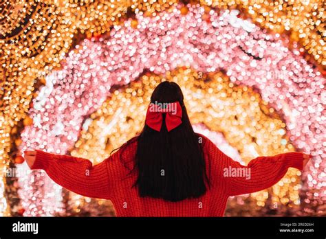 Woman With Long Black Hair In A Knitted Cozy Red Sweater And A Bow In