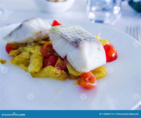 Baked Sea Bass With Fried Vegetables And Roasted Cherry Tomatoes Stock