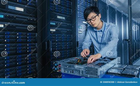In The Modern Data Center It Technician Working With Server Racks On