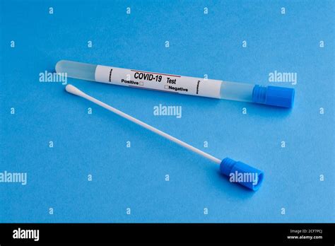 Cotton Stick For Buccal Swab And Test Tube For COVID 19 Diagnostics On Blue Background Stock