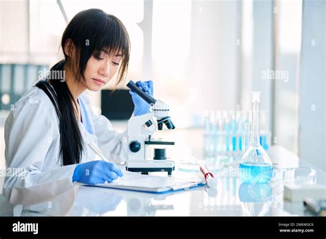 Beautiful Female Scientist Analyzing Microscope Slides Working In Modern Science Laboratory