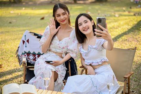 Two Beautiful Young Asian Women Picnic In The Green Park Together