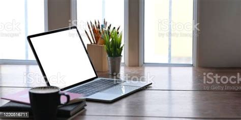 나무 작업 책상에 넣어 노트북 커피 컵 화분 연필 홀더와 마커 펜에 둘러싸여 흰색 빈 화면 노트북 순서대로 작업 영역 개념입니다