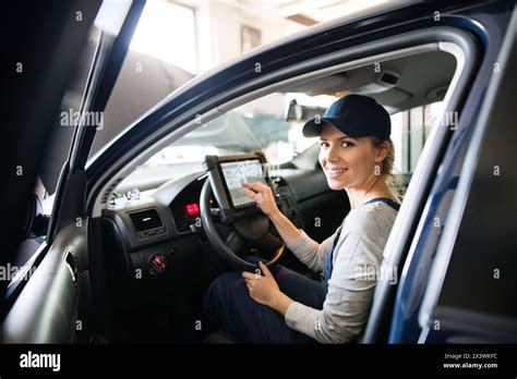 Female Auto Mechanic Using Diagnostic Tool Scanner Running Diagnostic On Car Beautiful Woman