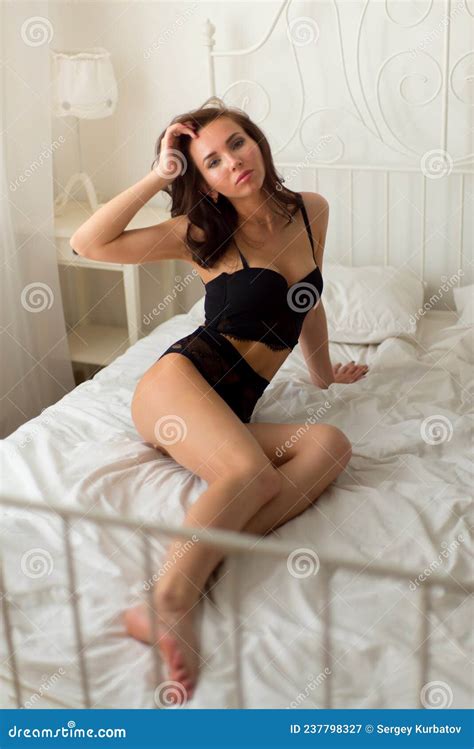 Beautiful And Brunette Young Woman Wearing Black Lingerie In Bed