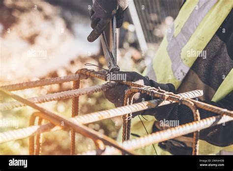 A Worker Uses Steel Tying Wire To Fasten Steel Rods To Reinforcement