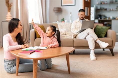 Mamá Japonesa Enseñando A Su Pequeña Hija Sentada En Casa Foto Premium